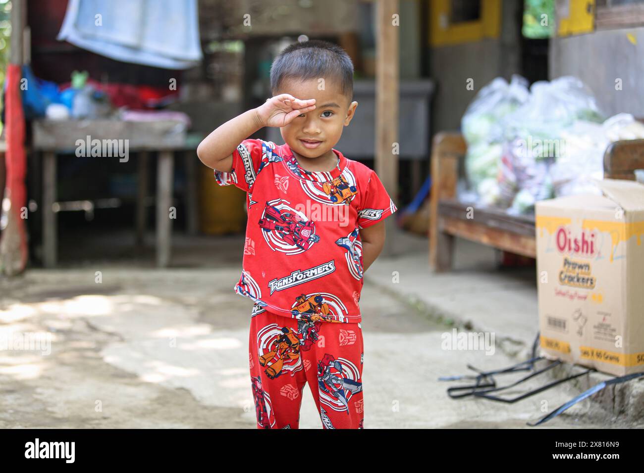 A young Filipino boy play with the camera by posing & asking for more ...