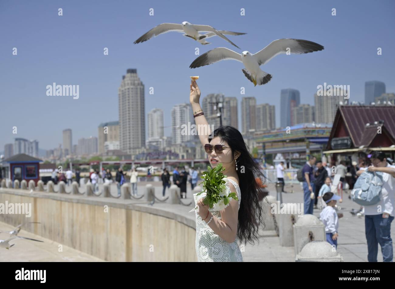 Dalian, China's Liaoning Province. 22nd May, 2024. A tourist poses for ...