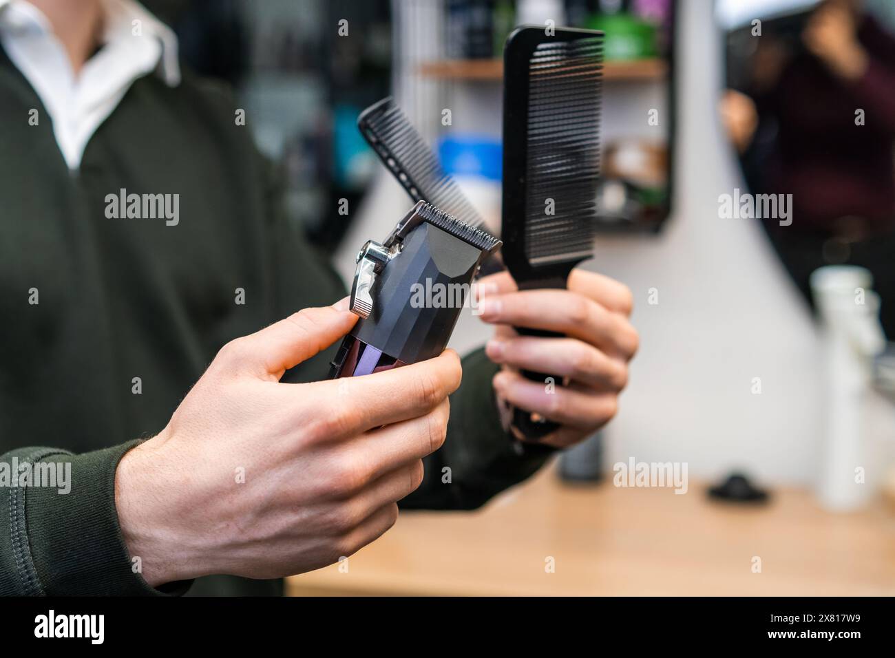 Barber holding combs and trimmer in the barbershop Stock Photo - Alamy