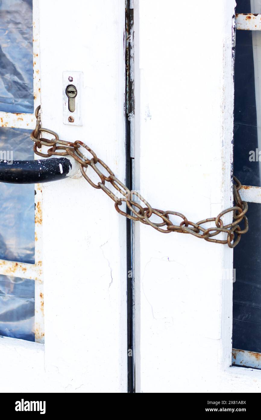 a white door with a chain attached to it Stock Photo - Alamy