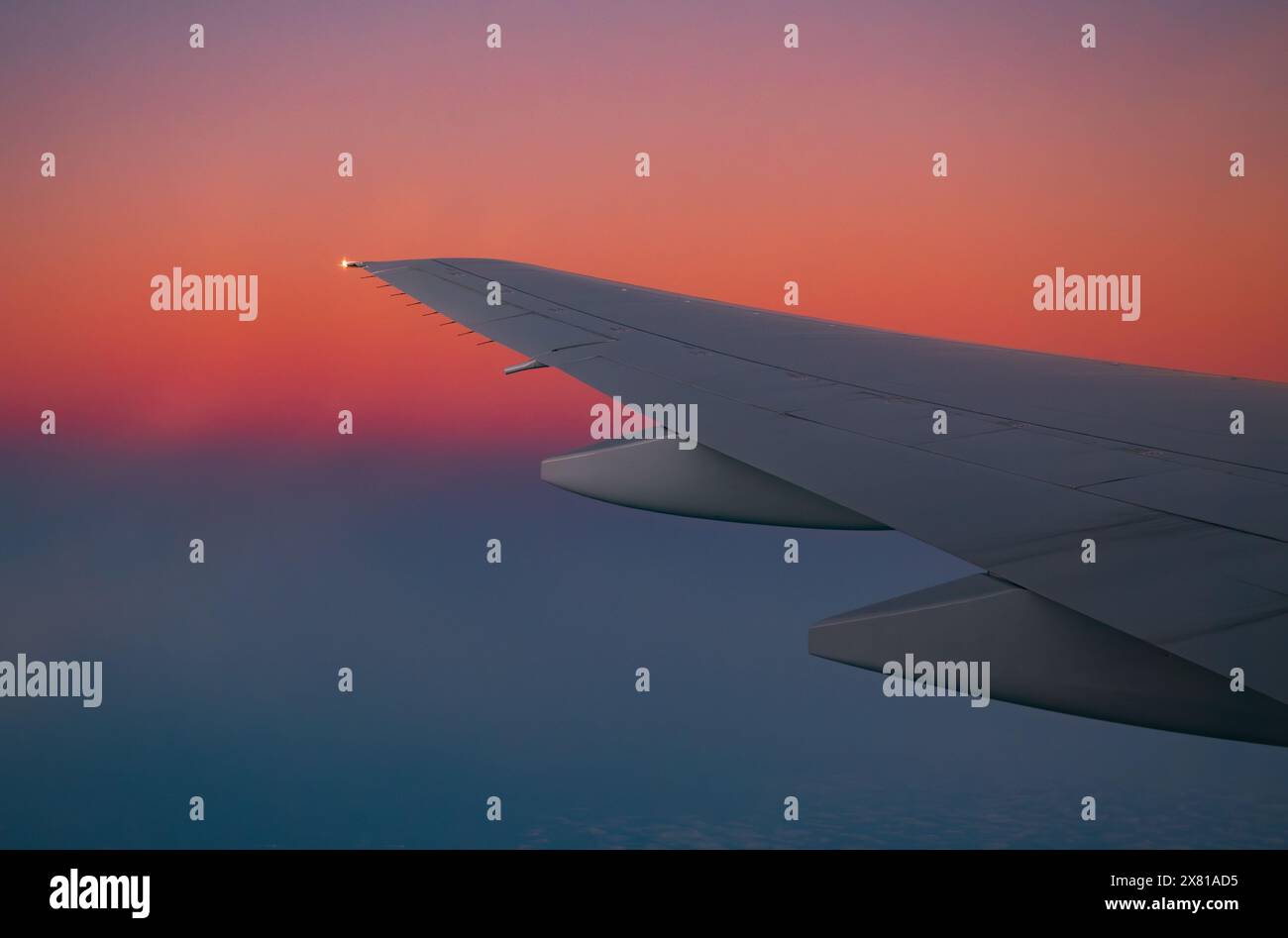 Airplane wing in flight during sunset with vibrant sky Stock Photo - Alamy