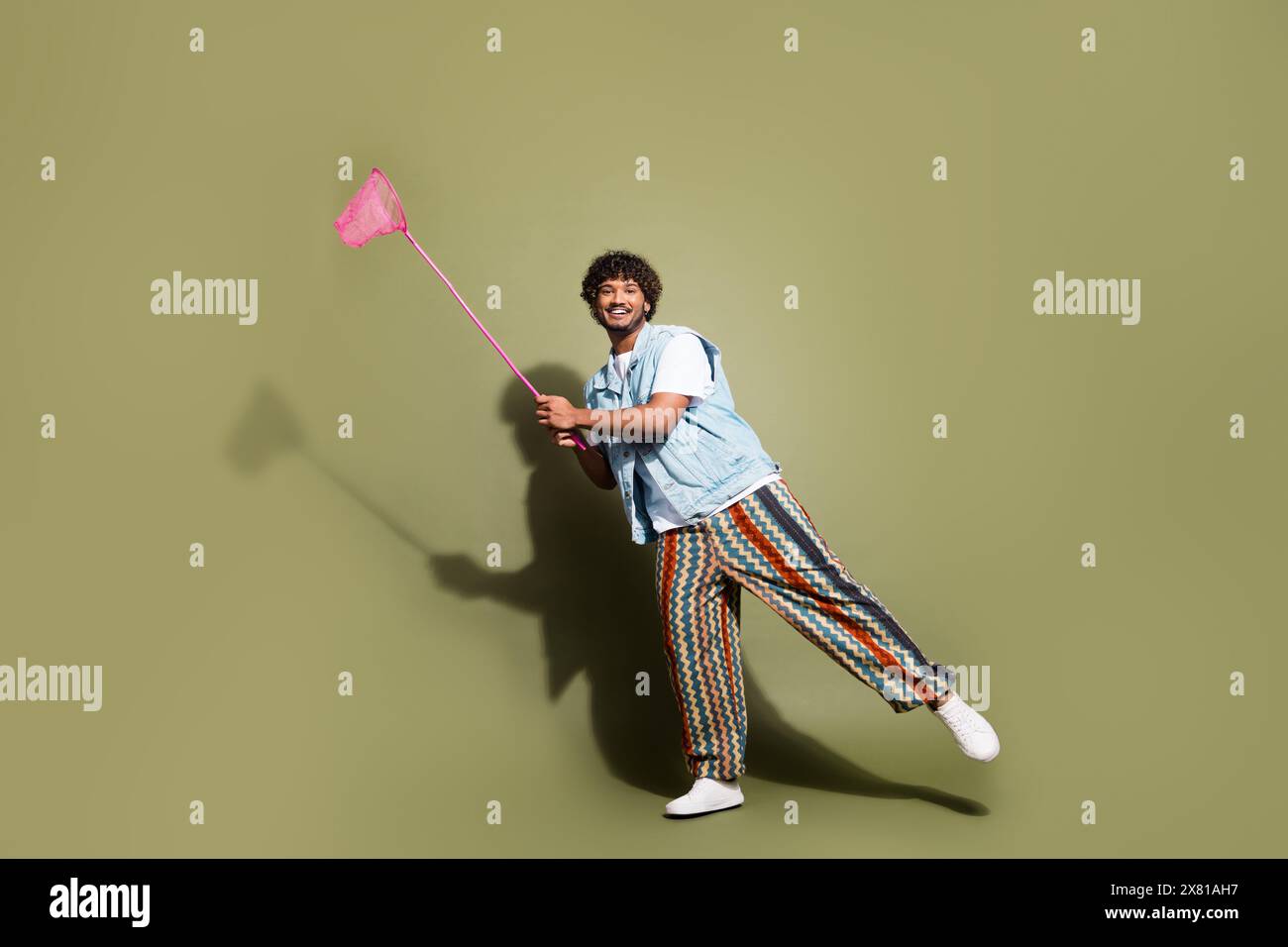 Full body photo of attractive young man catch butterflies dressed ...
