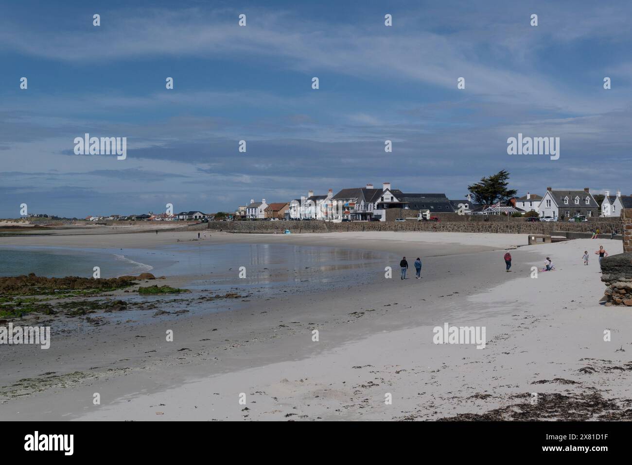 Looking along the impressive popular white sandy beach of Cobo Bay ...