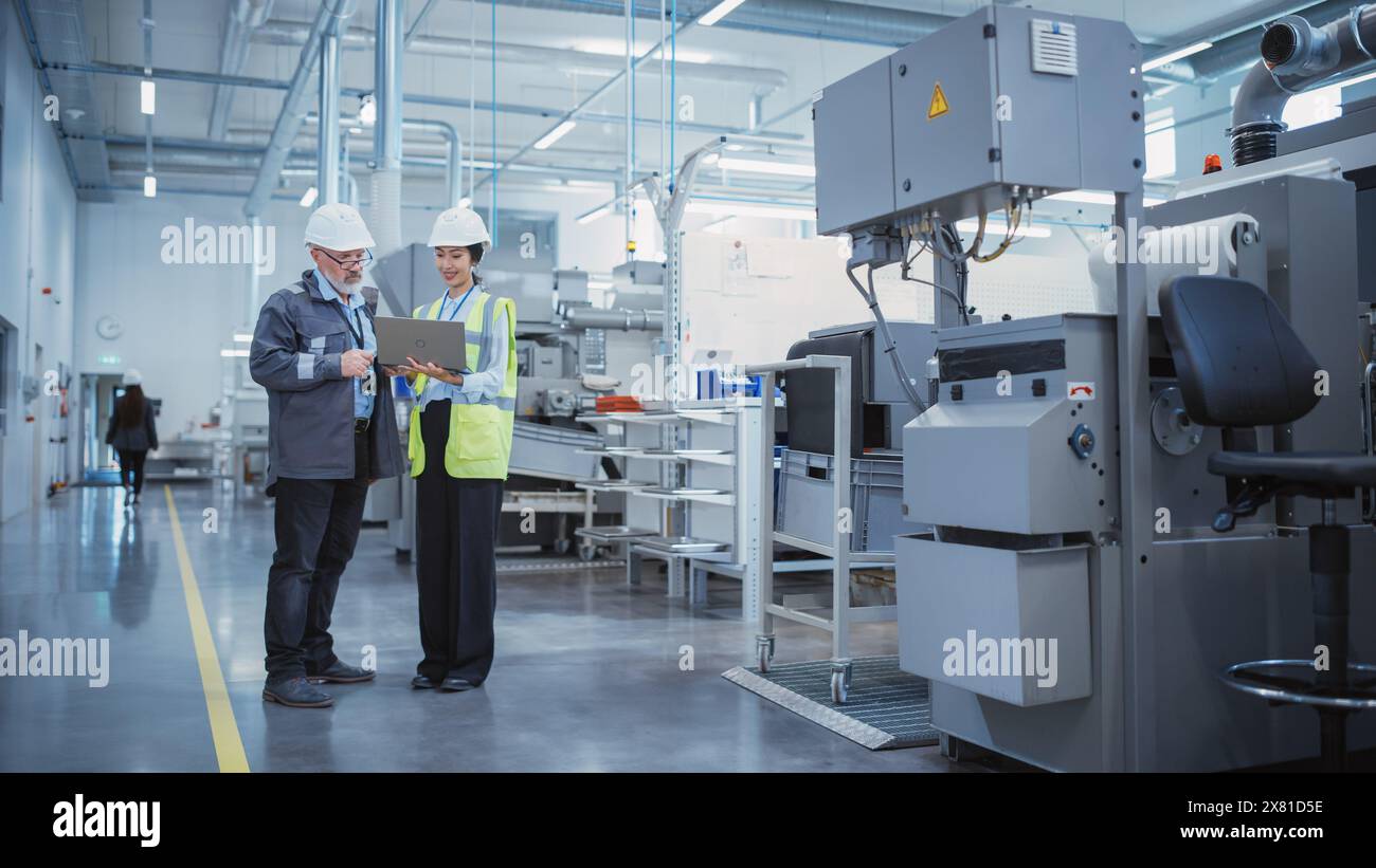 Two Professional Heavy Industry Employees in Hard Hats at Factory ...