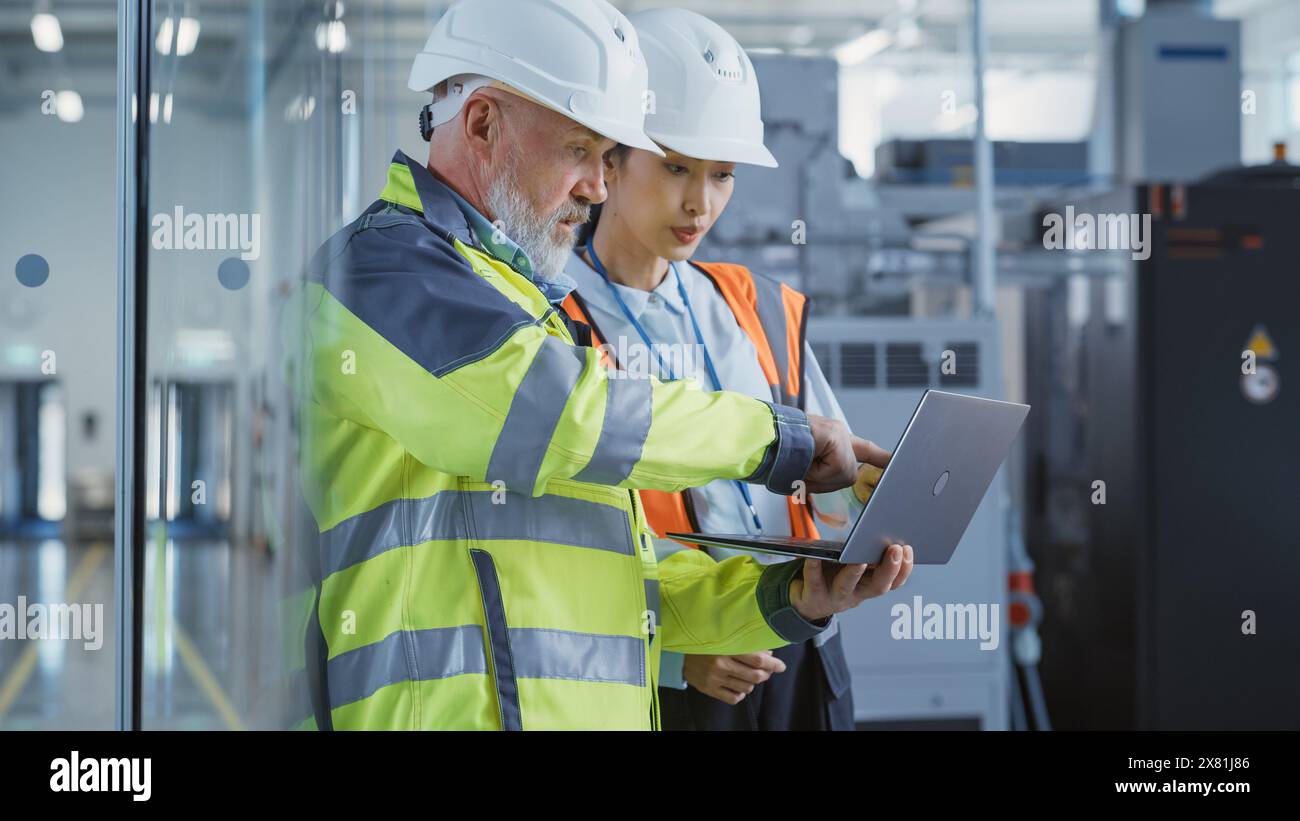 Two Diverse Heavy Industry Engineers in Safety Uniform and Hard Hats ...
