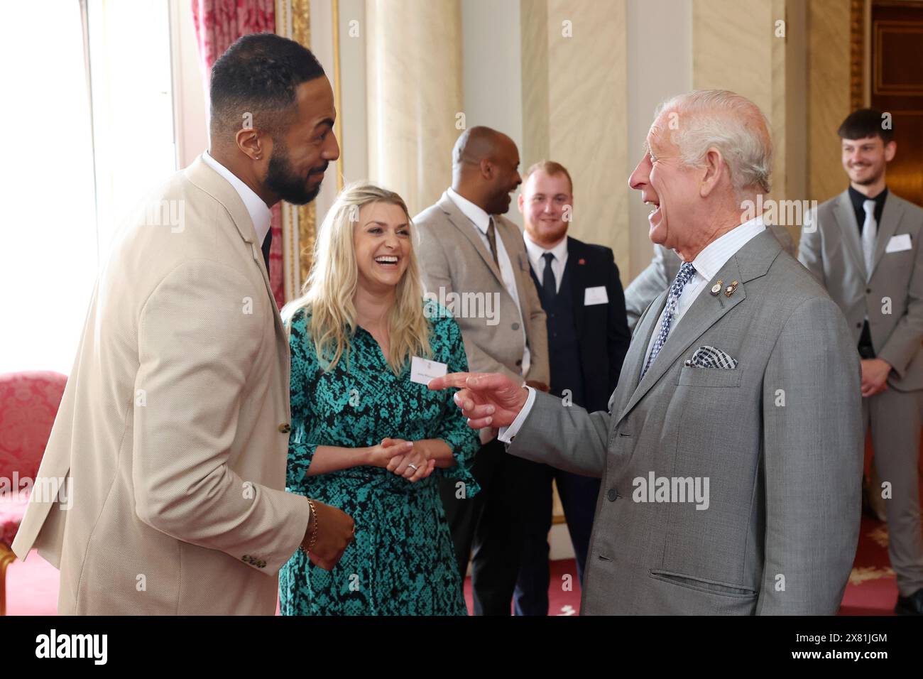 King Charles III and Tyler West (left) share a fist bump during a ...