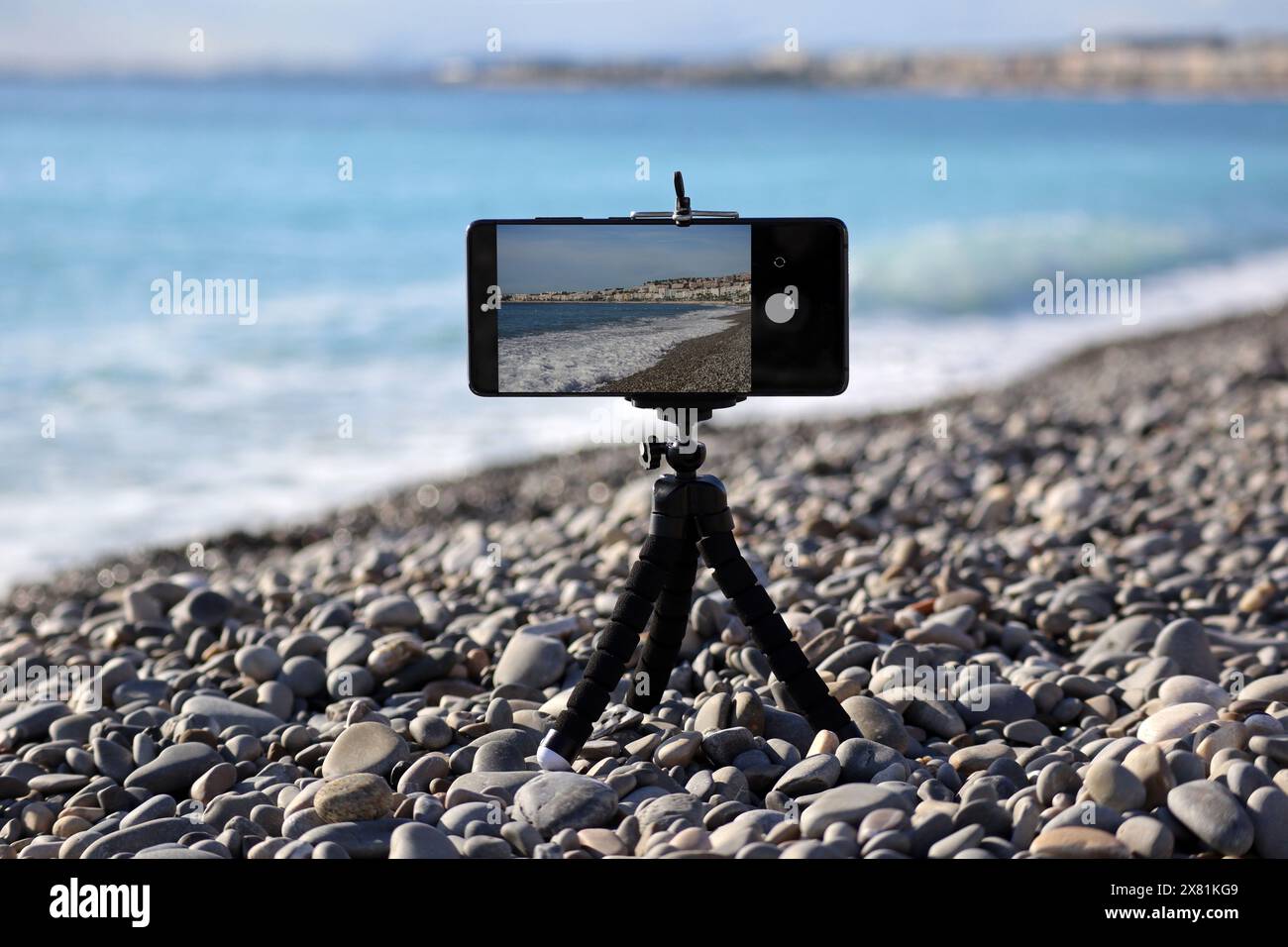 Smartphone on the pebble beach in Nice, taking photo of the sea shore ...