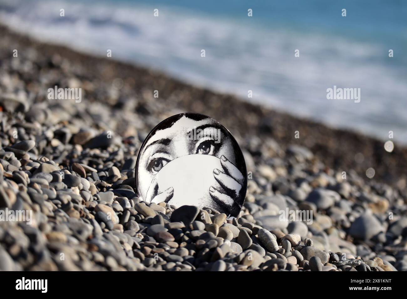 Fornasetti plate on the pebble beach, the face belongs to Italian opera ...