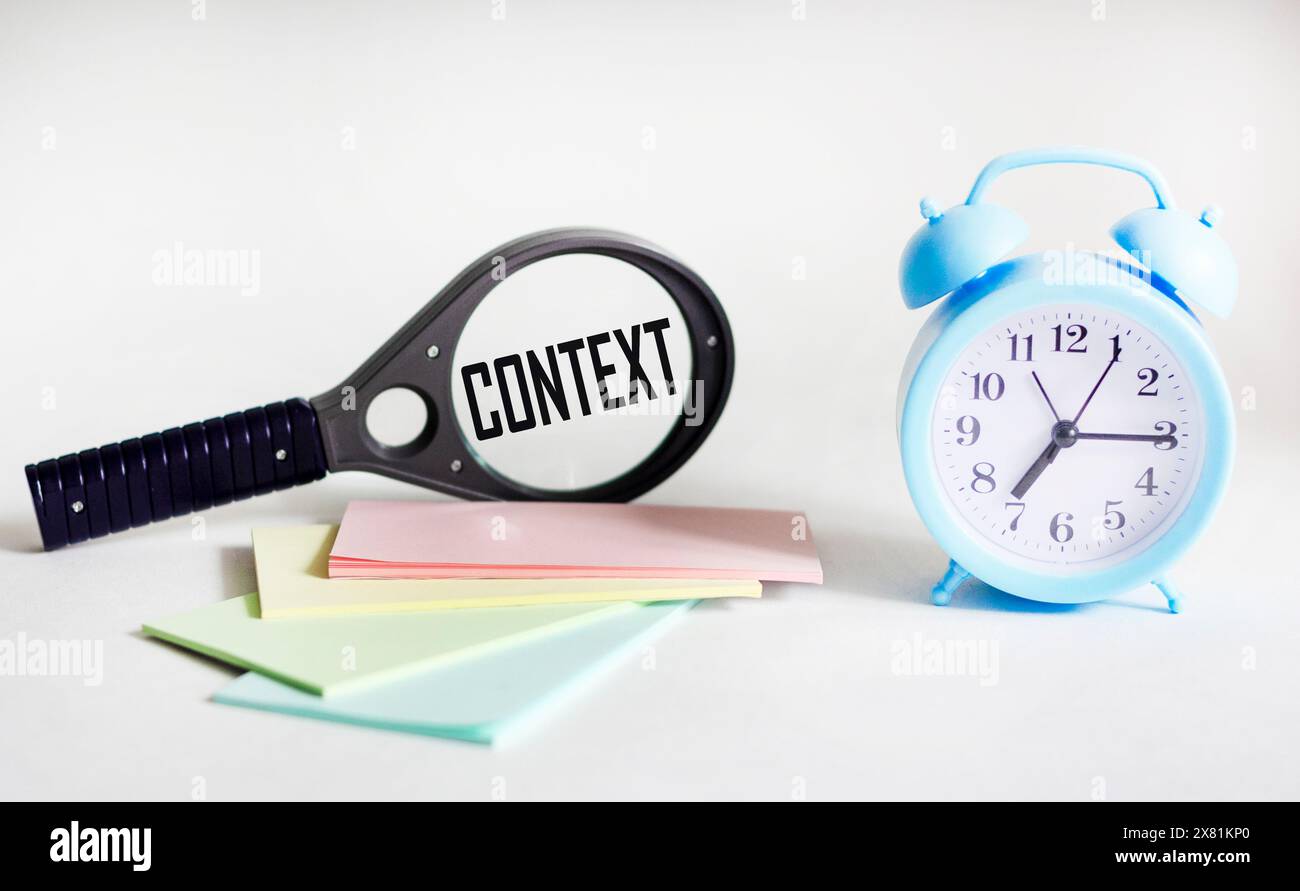 CONTEXT text on magnifying glass and white background with clock and ...