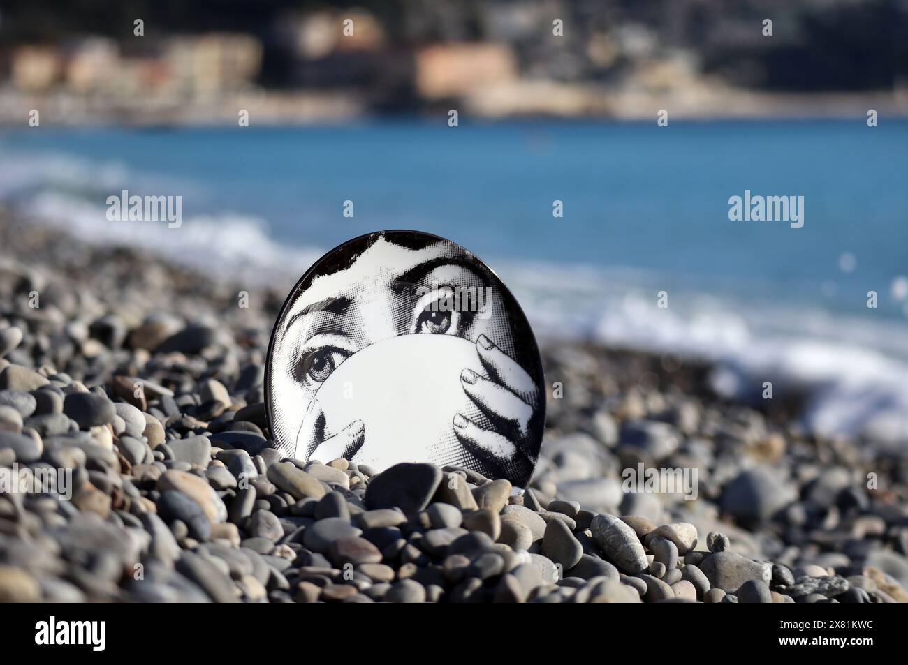 Fornasetti plate on the pebble beach, the face belongs to Italian opera ...