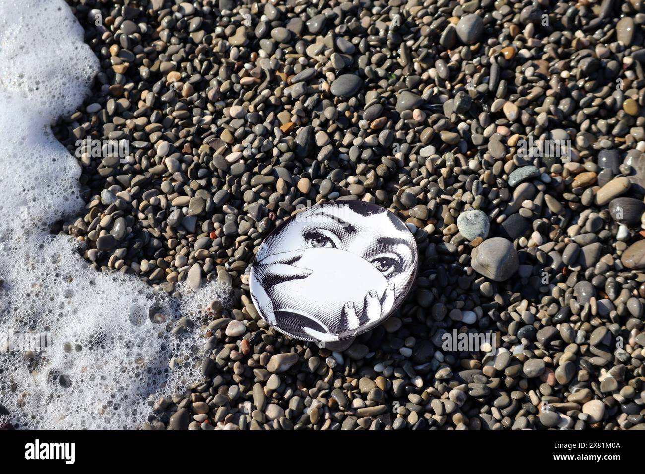 Fornasetti plate on the pebble beach, the face belongs to Italian opera ...