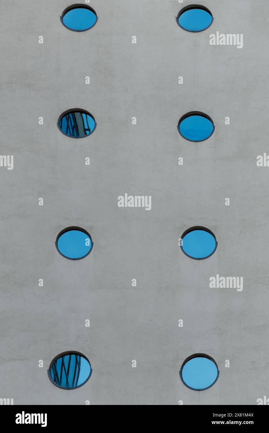 Small round windows on the concrete wall of the building. Details and ...