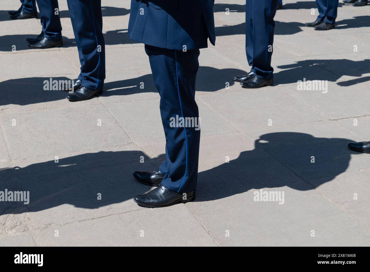 Men in identical blue suits stand in a linear formation Stock Photo - Alamy