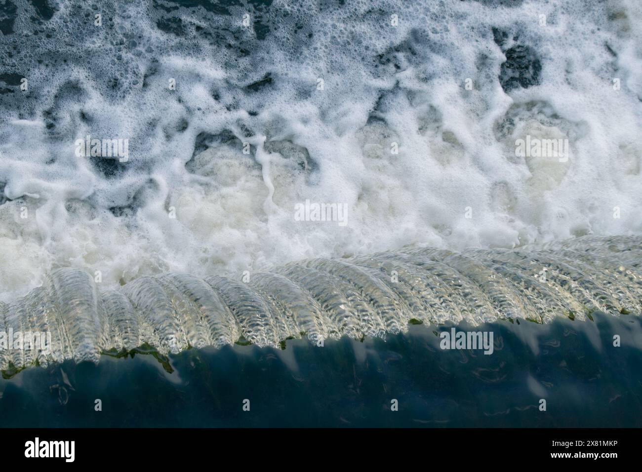 Streams of water fall from a water dam. Water foam. Waterfall Stock ...