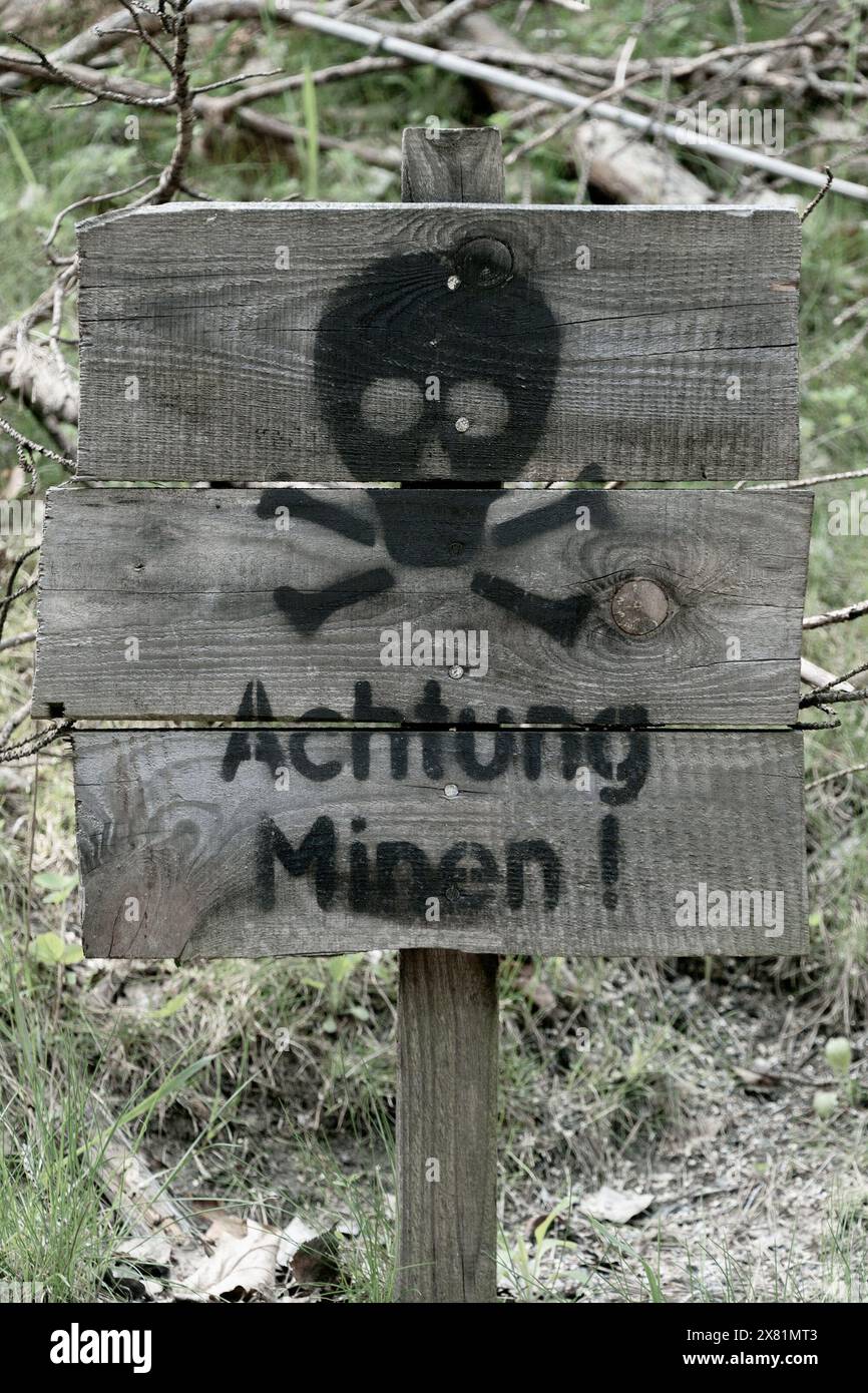 Wooden sign with the inscription "Achtung Minen". Be careful, mines ...