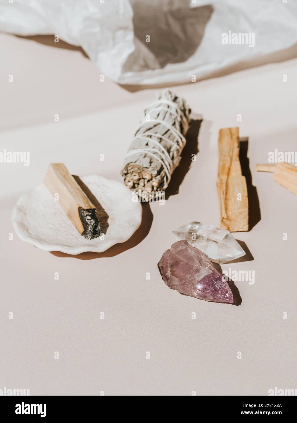 White sage and Palo Santo and amethyst and quartz crystals on a light ...