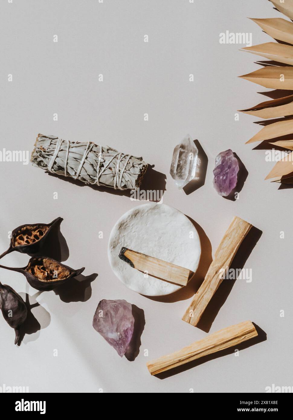White sage and Palo Santo and amethyst and quartz crystals on a light ...