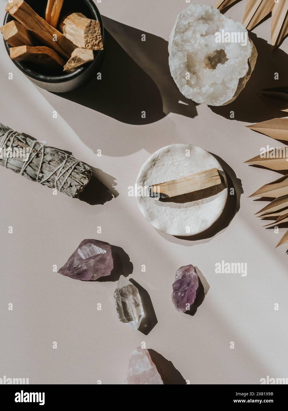 White sage and Palo Santo and amethyst and quartz crystals on a light ...