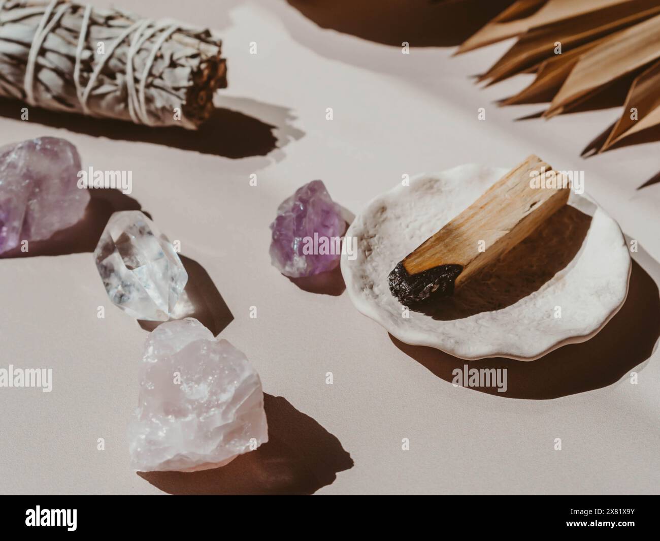 White sage and Palo Santo and amethyst and quartz crystals on a light ...
