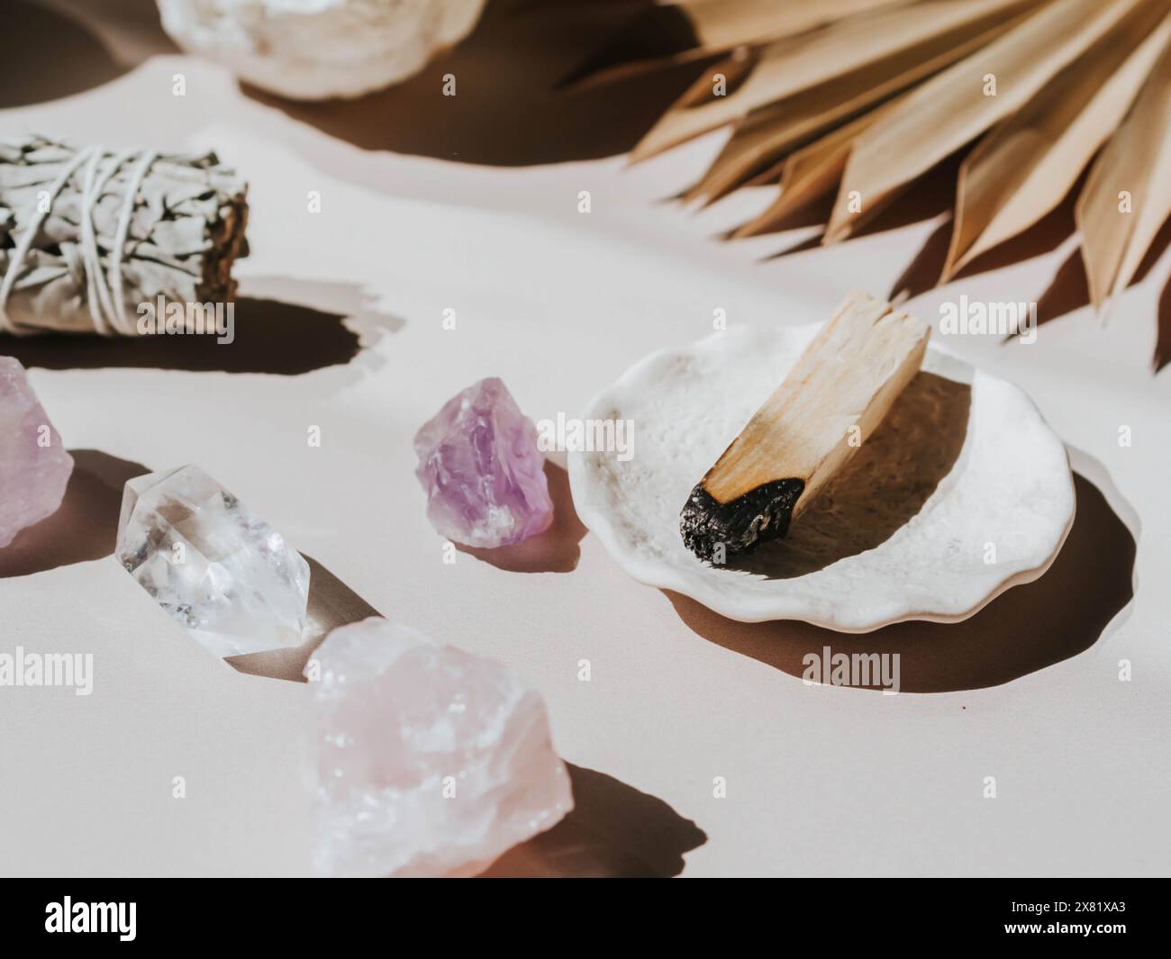 White sage and Palo Santo and amethyst and quartz crystals on a light ...