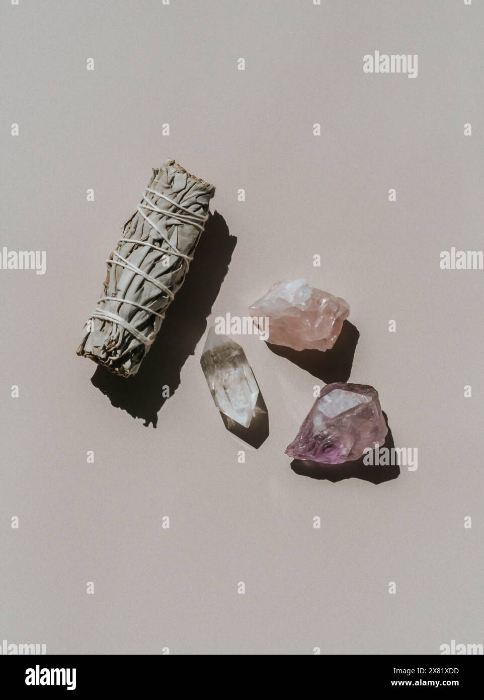 White sage and amethyst and quartz crystals on a light beige background ...