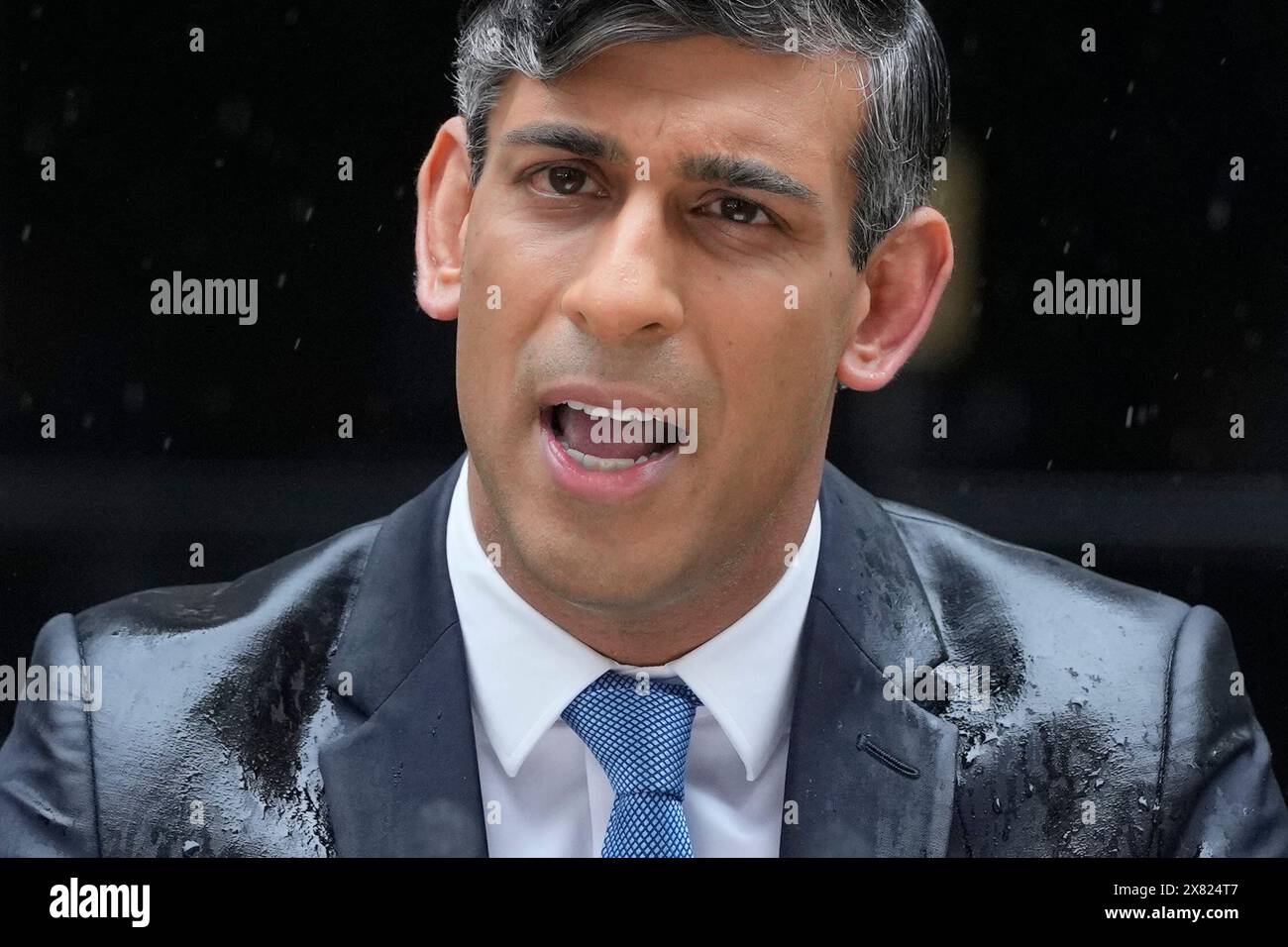 Britain's Prime Minister Rishi Sunak speaks to the media, as heavy rain ...
