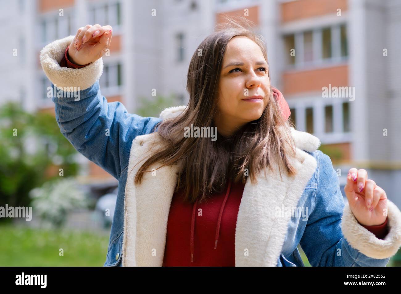 A woman is energetically dancing in the forest. She exudes confidence ...