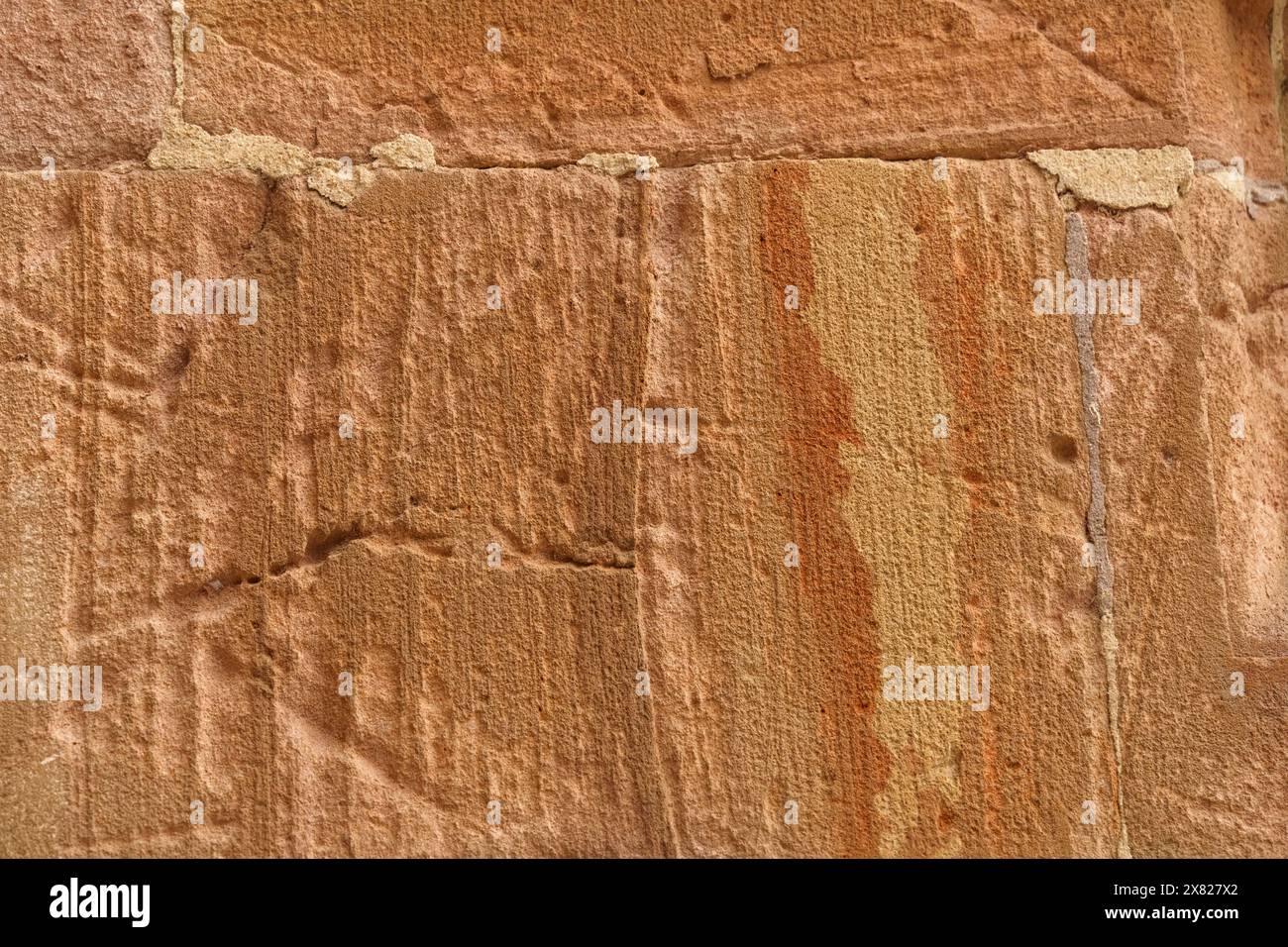 Detailed close-up view of a brick wall with vibrant red paint peeling ...