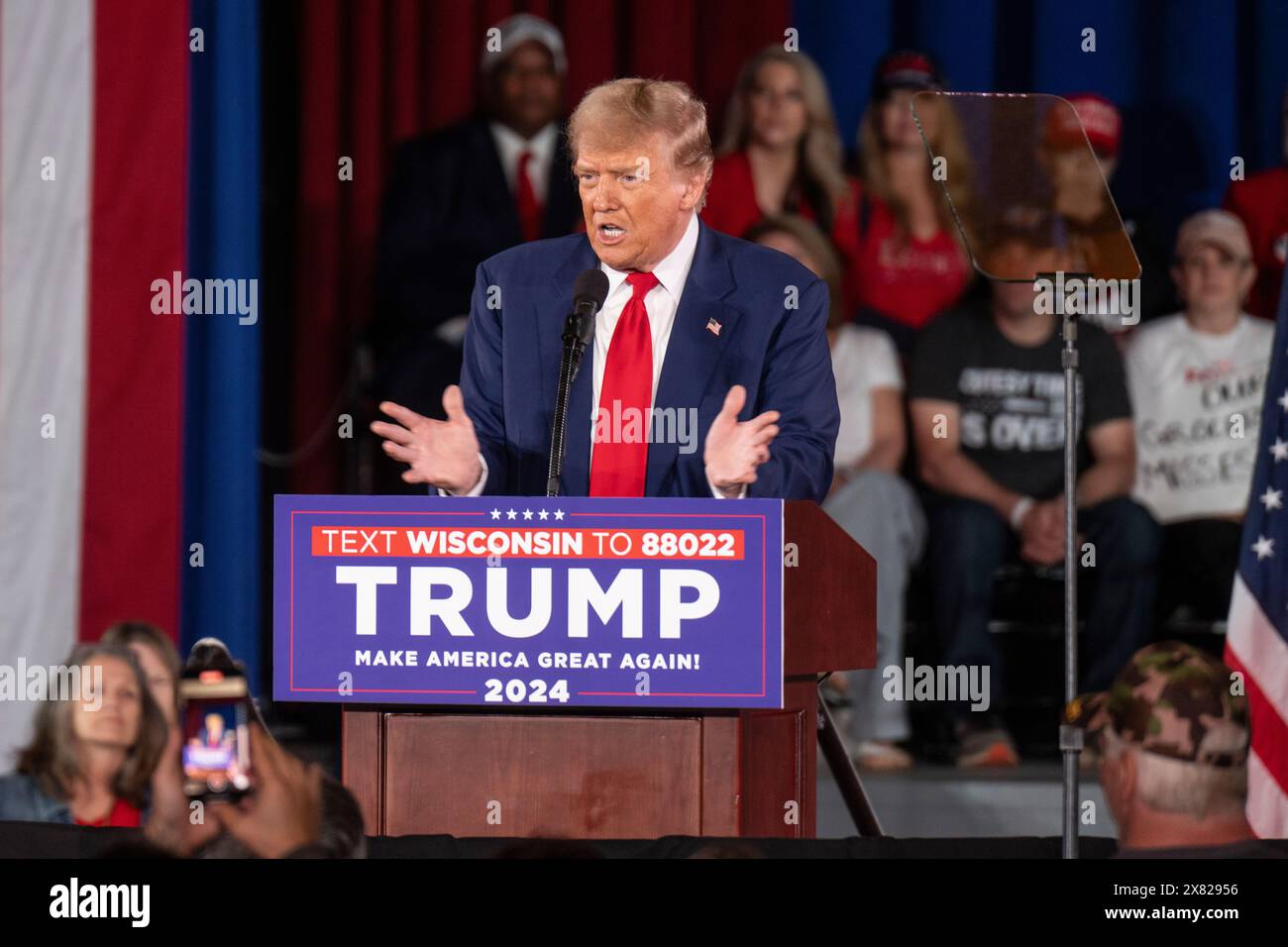 Donald Trump speaks on stage and uses hand gestures at a campaign rally ...