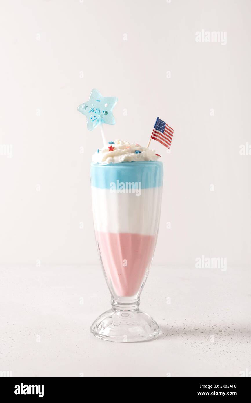 Layered milkshake or sweet dessert in red, white and blue colors ...