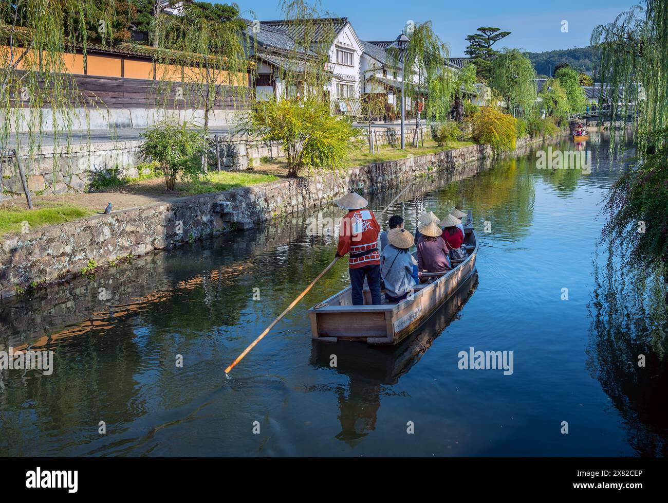 Historical quarter of Kurashiki, with a boat punting up the river on a ...