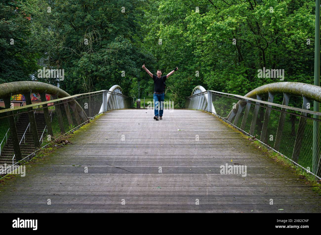 Man walking over a pedestrian bridge at Peterbos, Anderlecht, Brussels ...