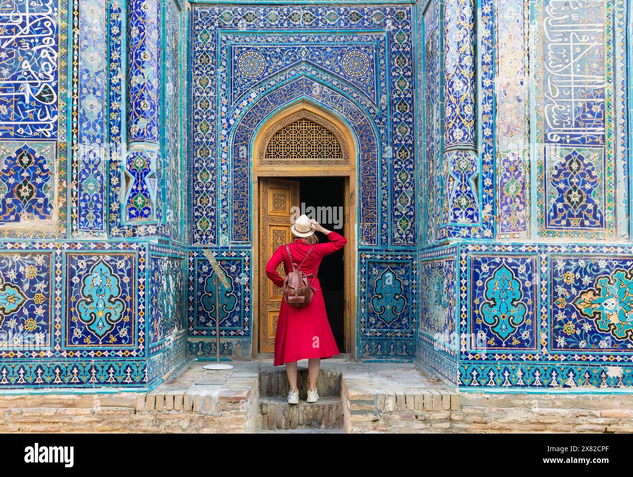 tourist woman in red dress clothes stands near an ancient architectural ...