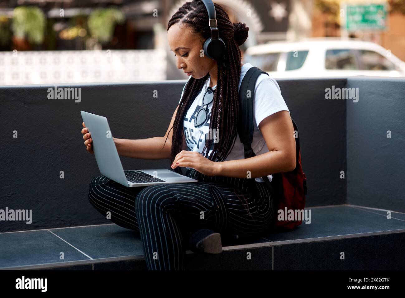 Woman, student and headset with laptop outside, typing and online ...