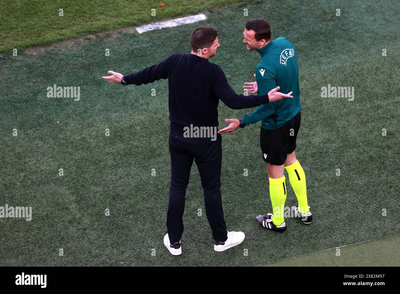 Bayer Leverkusen manager Xabi Alonso (left) speaks with the fourth ...