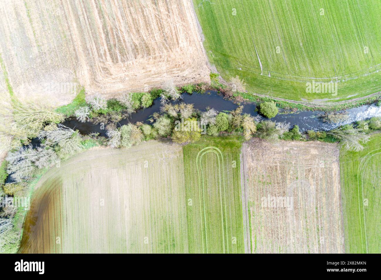 Aerial overhead view of a river winding through agricultural fields ...