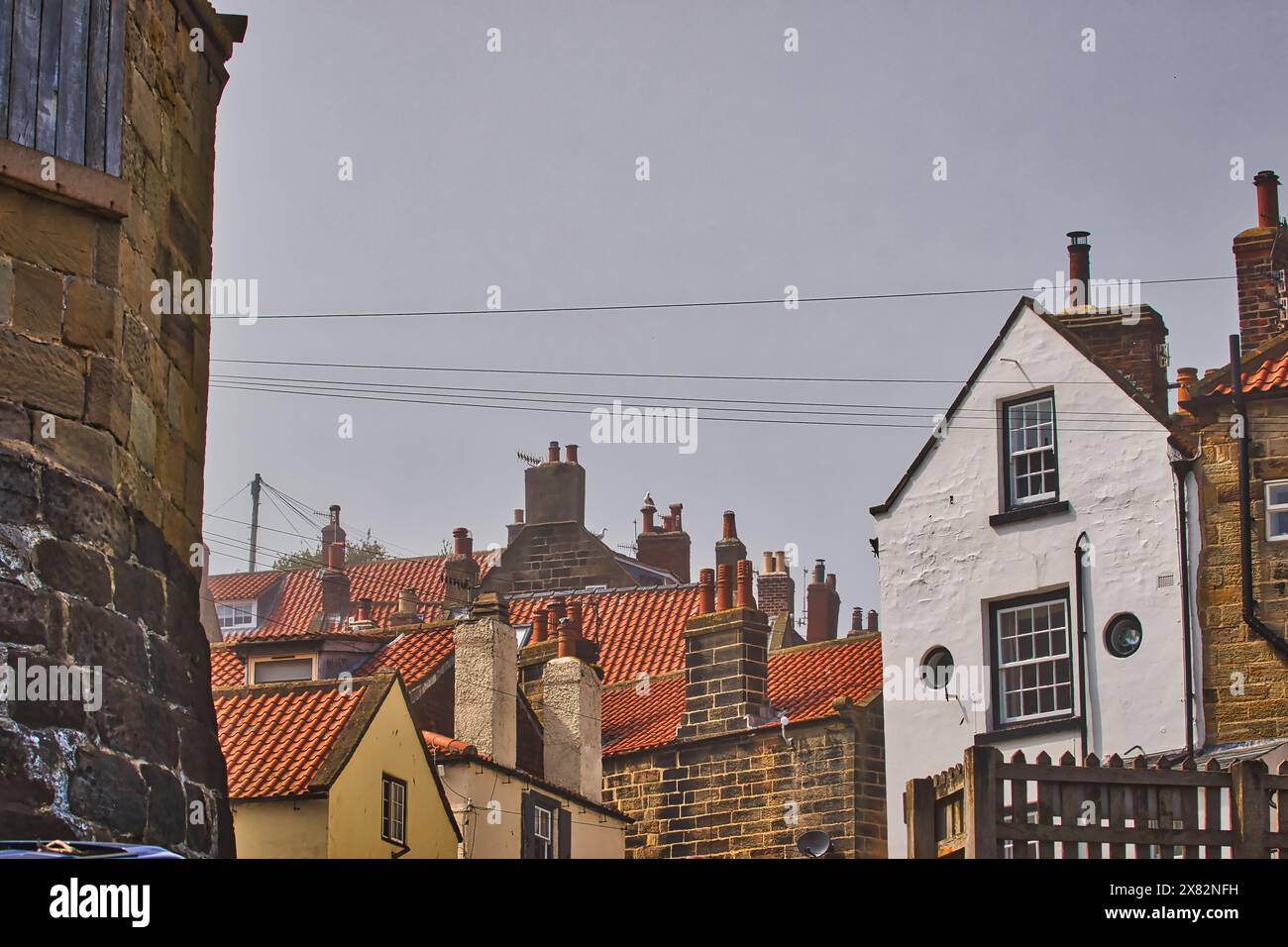 A scenic view of a quaint village with red-tiled rooftops and stone ...