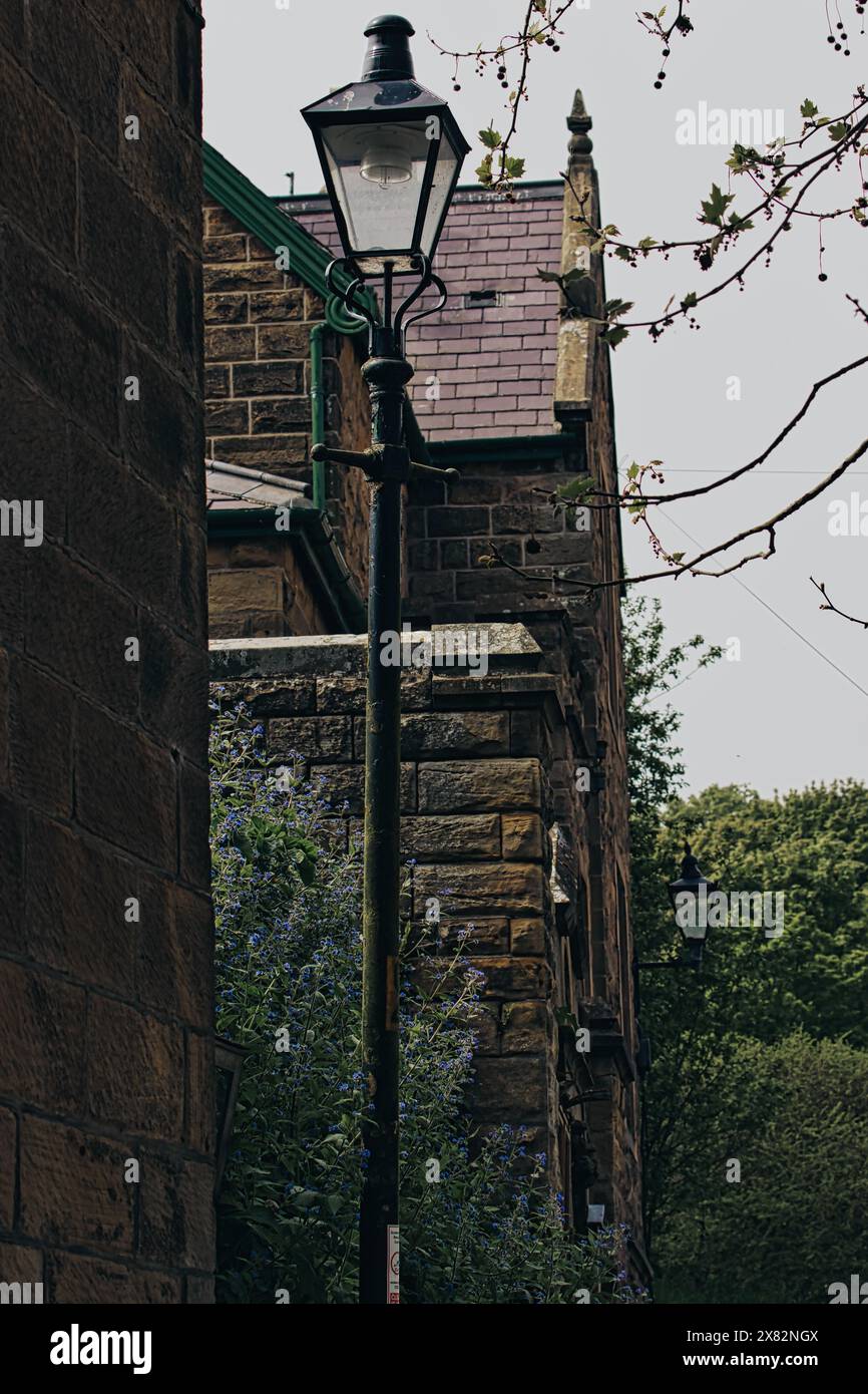 A vintage street lamp post in front of an old stone building with a ...
