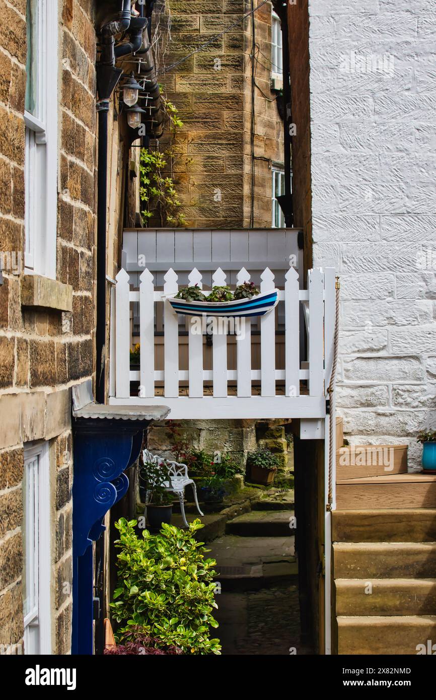 A narrow alleyway between two buildings with a small balcony featuring ...