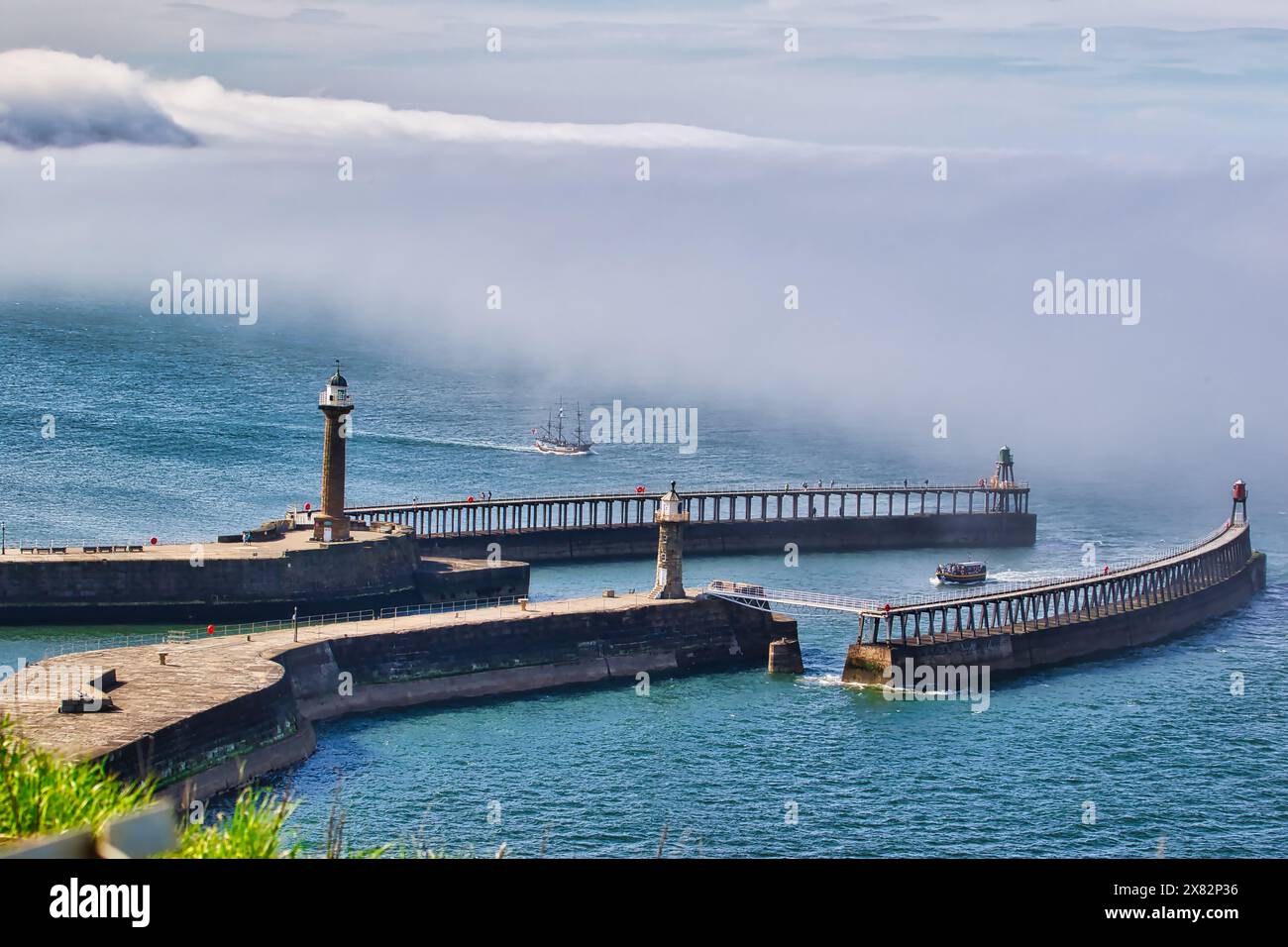 Aerial view of a coastal harbor with two piers extending into the sea ...