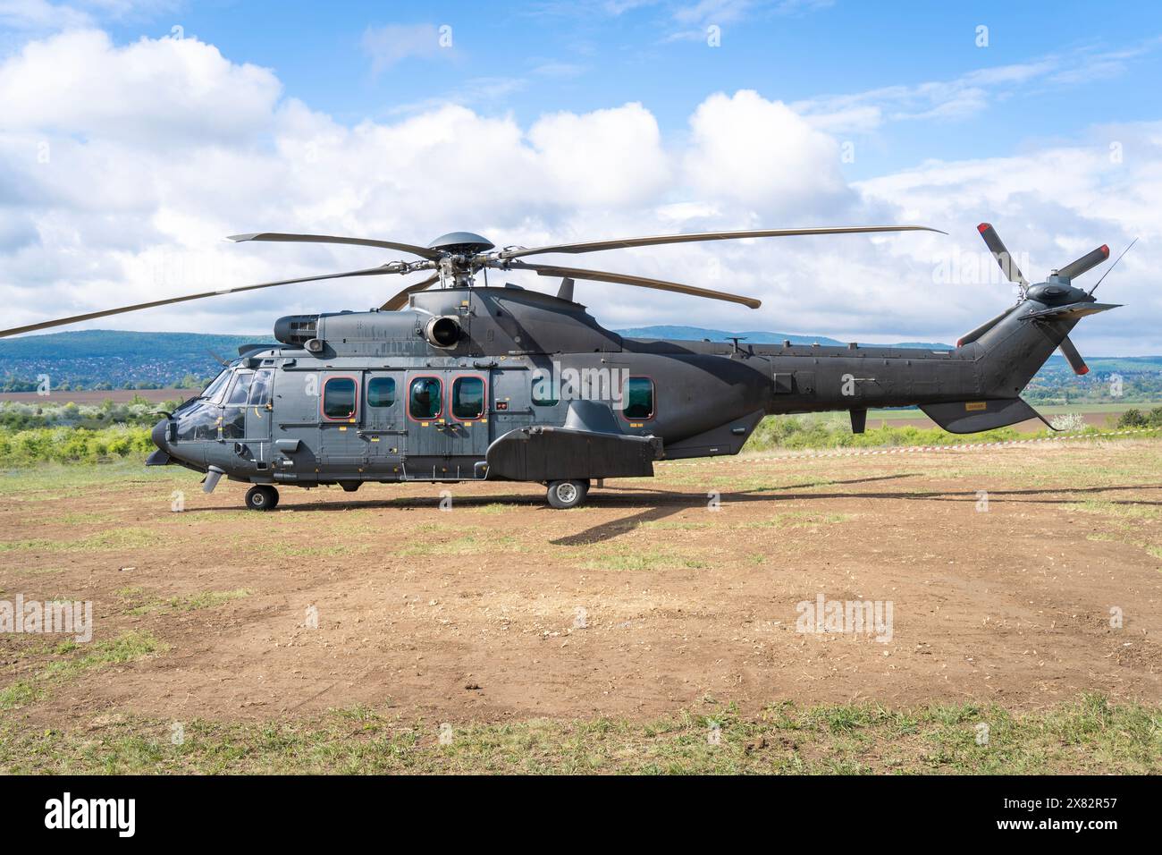 Black painted modern H225M military transport helicopter stationary on ...