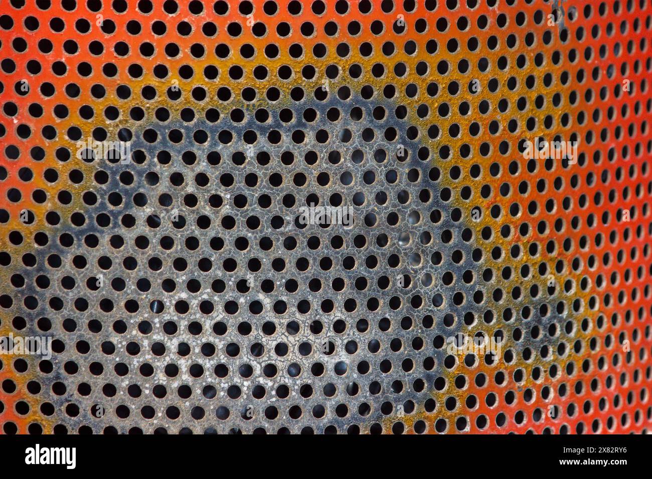 an abstract of a multi-colored metal background with circles holes ...