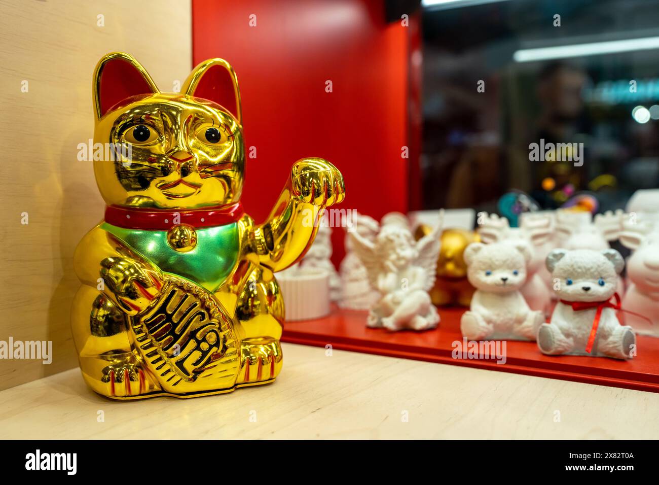 Maneki Neko, Japanese Lucky Cat in a gift shop window. Golden cat ...