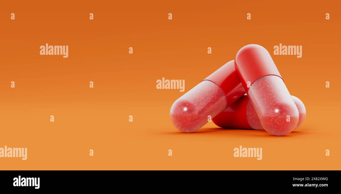 Three red transparent capsules, pills with red granules inside lay on ...