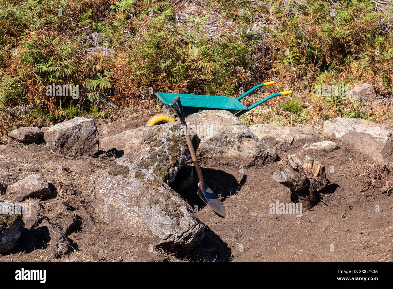 shovel and a wheelbarrow next to some rocks in an archaeological ...