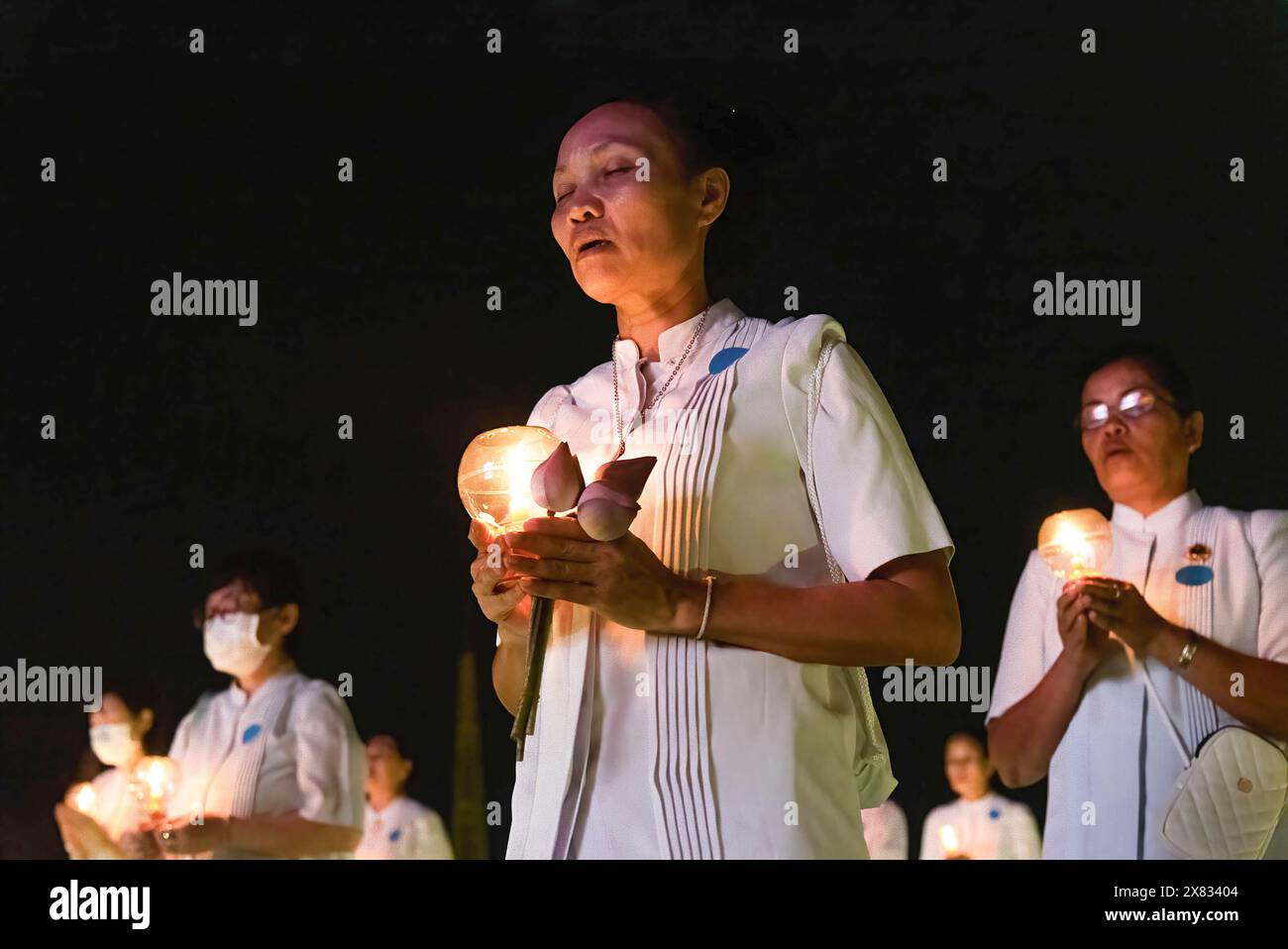 Pathum Thani, Thailand. 22nd May, 2024. Buddhist devotees pray during ...