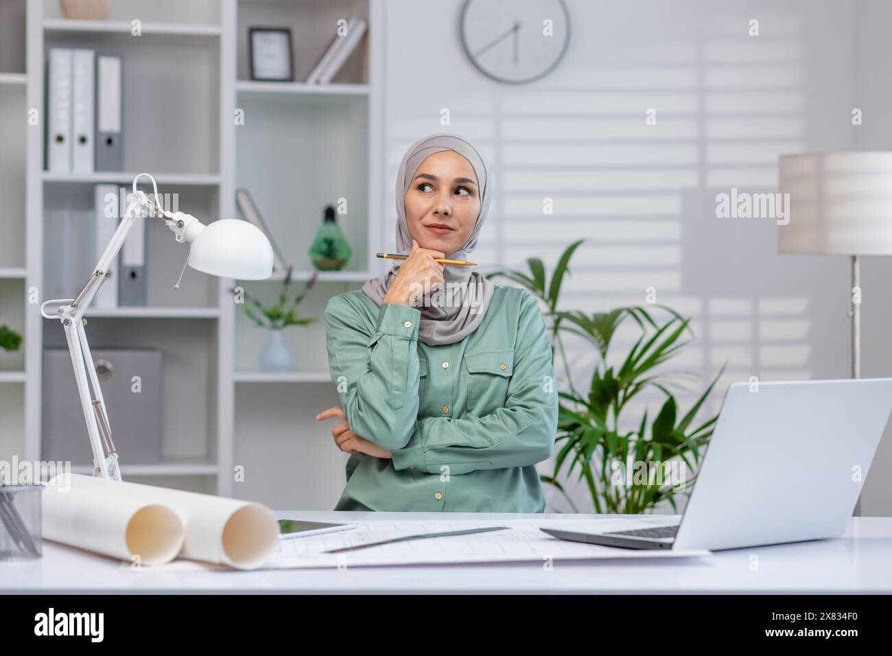 Young female architect thinking inside office, woman in hijab working ...