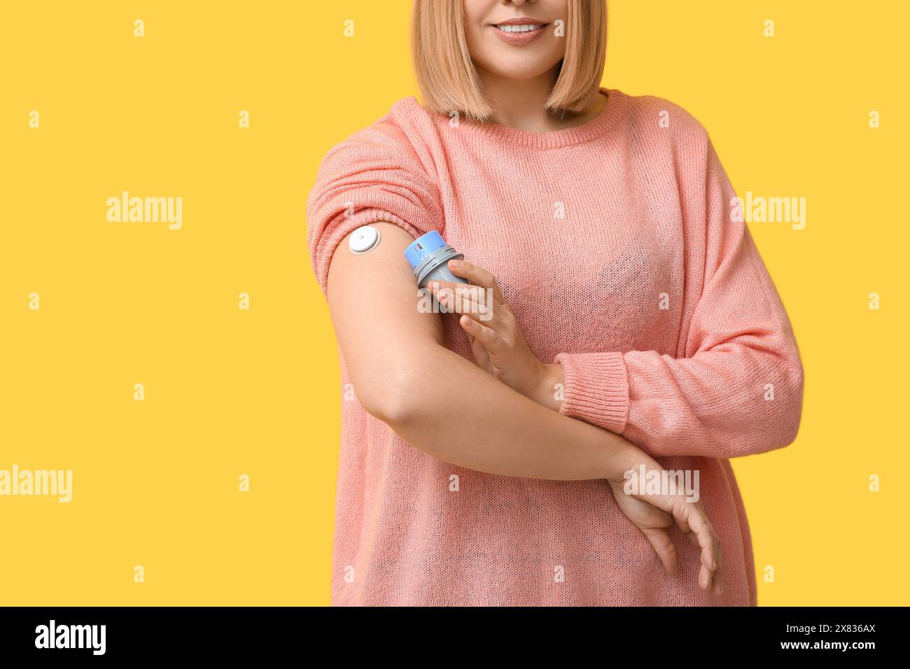 Woman with glucose sensor for measuring blood sugar level and ...