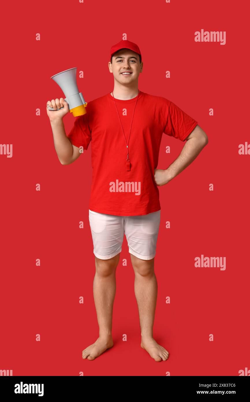 Male lifeguard with megaphone and whistle on red background Stock Photo ...