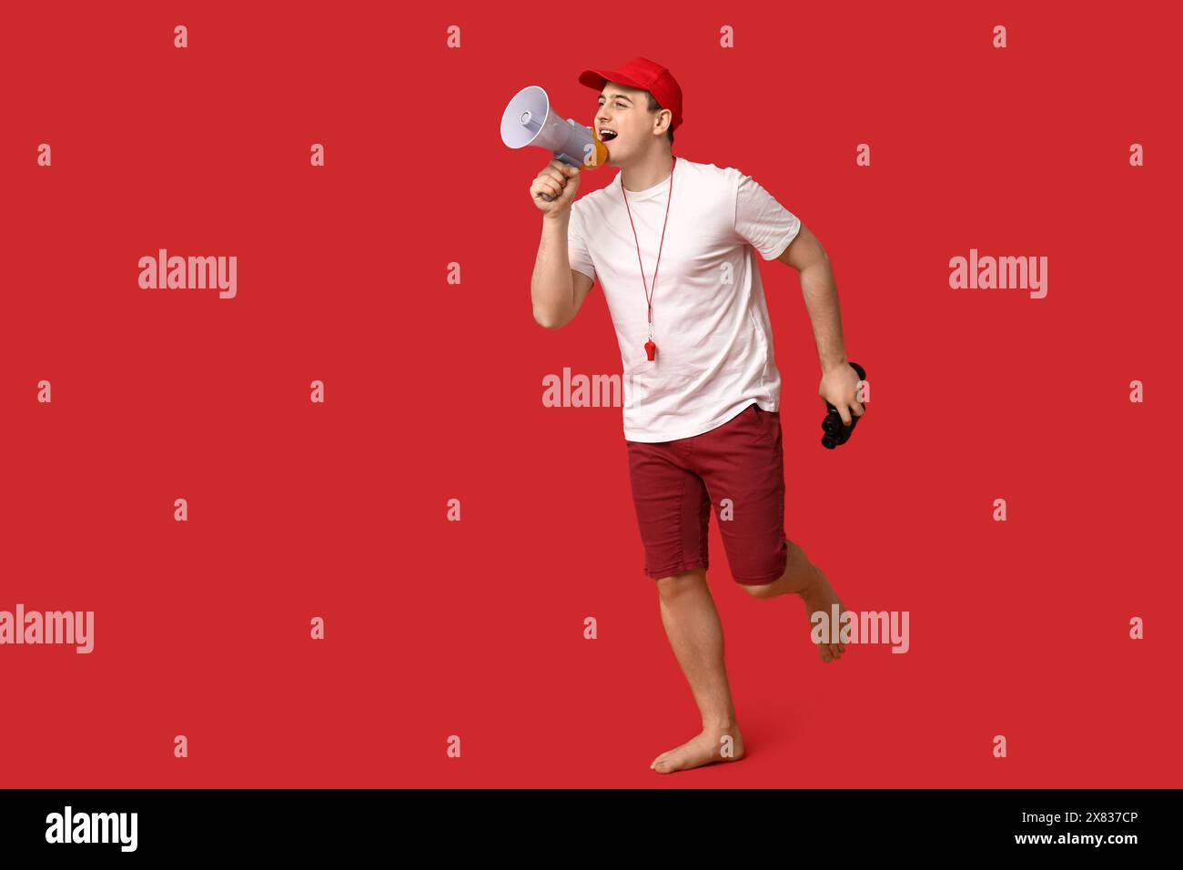 Male lifeguard with megaphone and binoculars running on red background ...